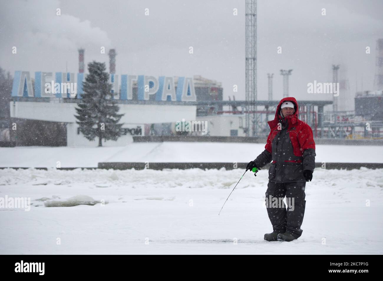 A Russian fisherman fishing on the ice of the Gulf of Finland in St ...