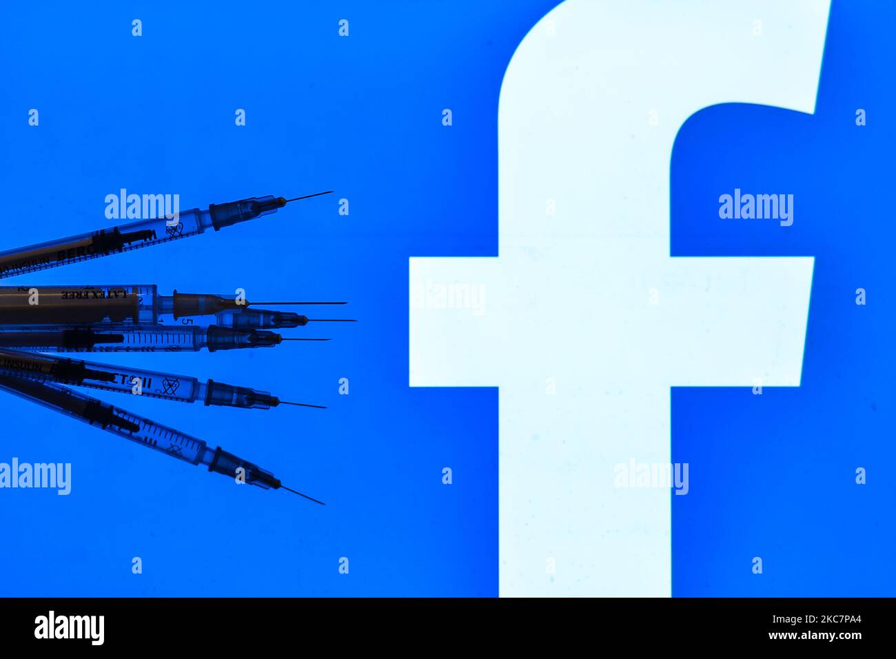 An illustrative image of medical syringes in front of Facebook logo ...