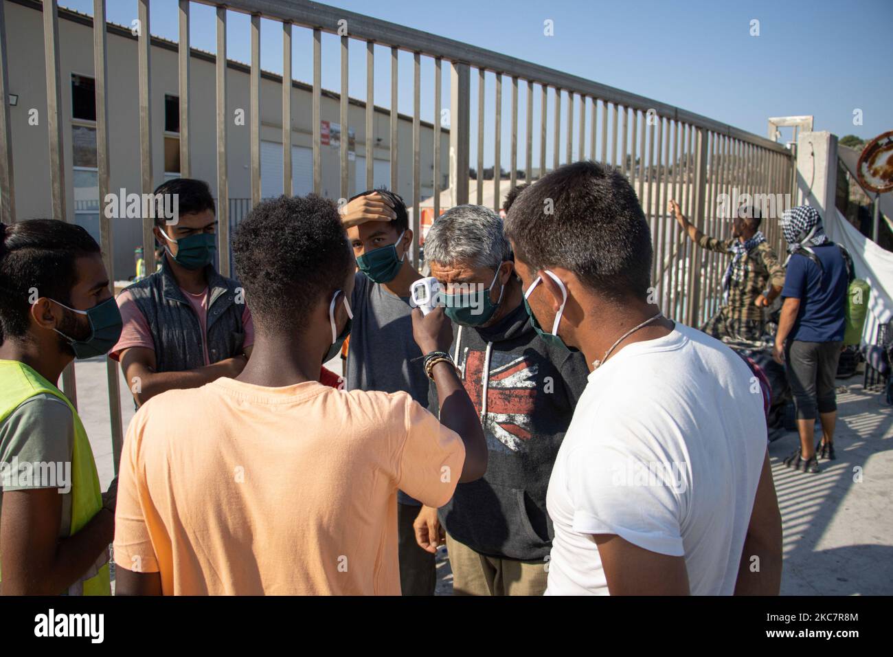 Asylum seekers have their body temperature checked by a handheld ...