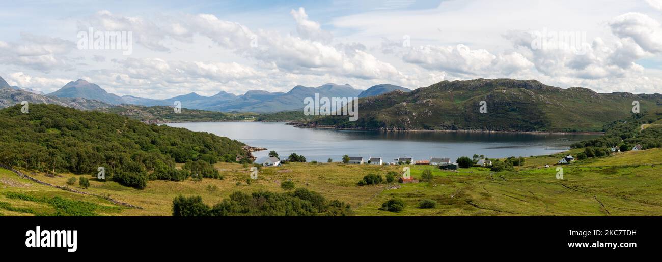 Water surrounded by white cottages and green grass covered mountains ...