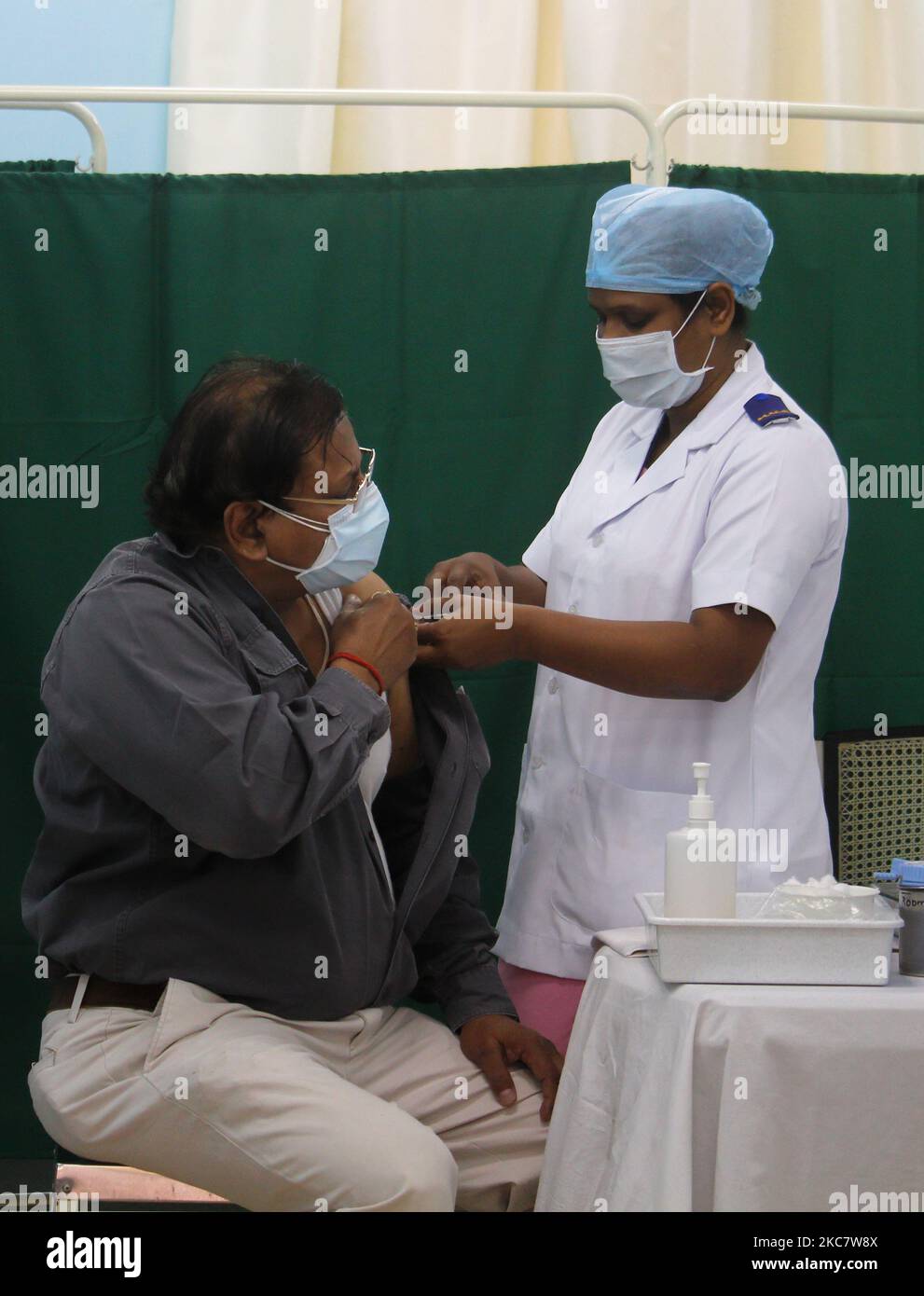 A medical staff member inoculates a man with COVID-19 vaccine at the ...