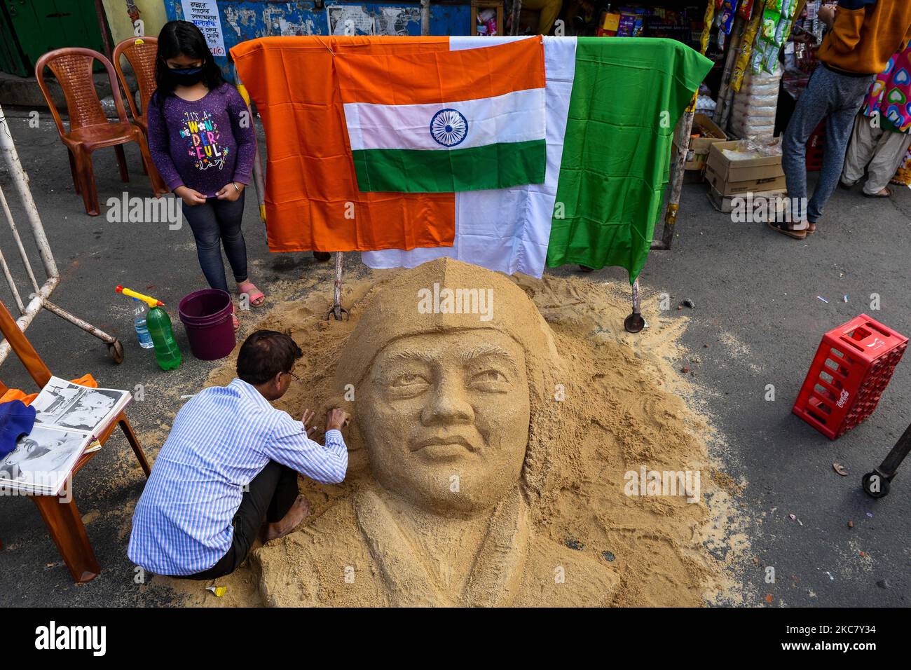 An artist gives final touches to a sand sculpture of Netaji Subhas ...
