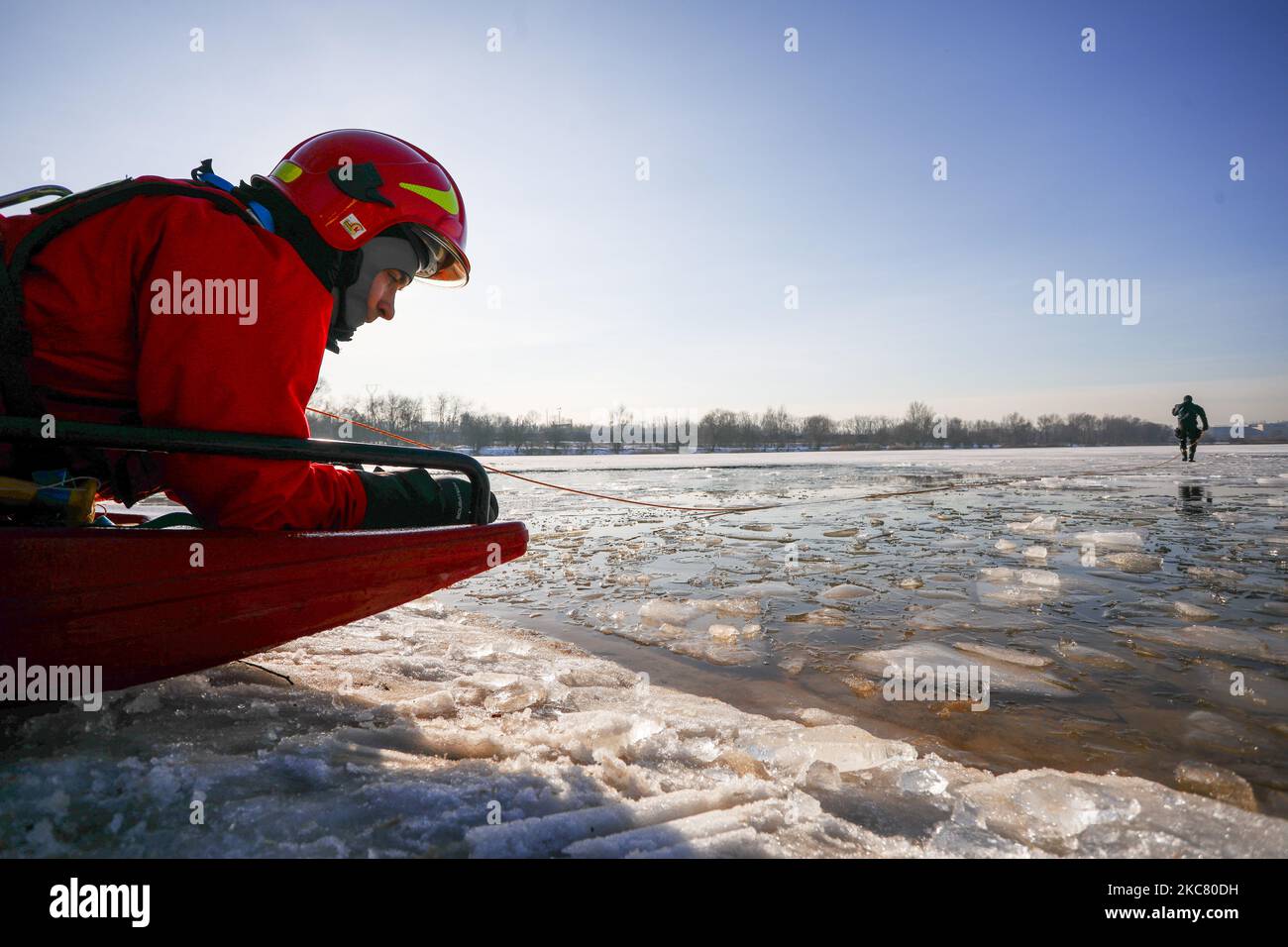 Firefighters wearing PPE conduct an ice rescue training exercise on a ...