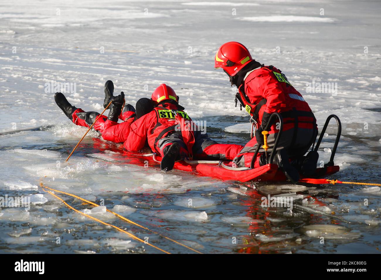 Firefighters wearing PPE conduct an ice rescue training exercise on a ...