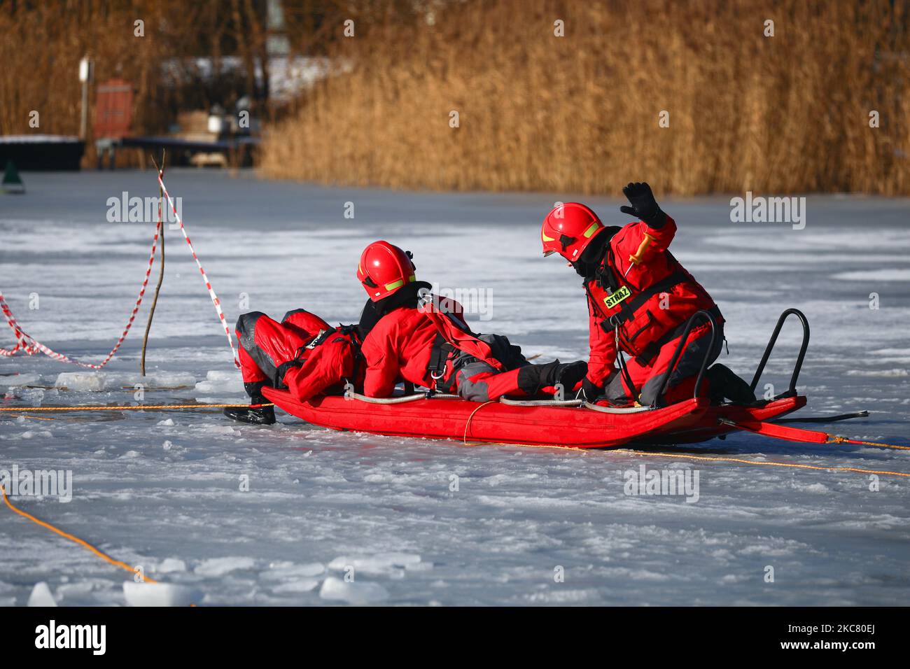 Firefighters wearing PPE conduct an ice rescue training exercise on a ...