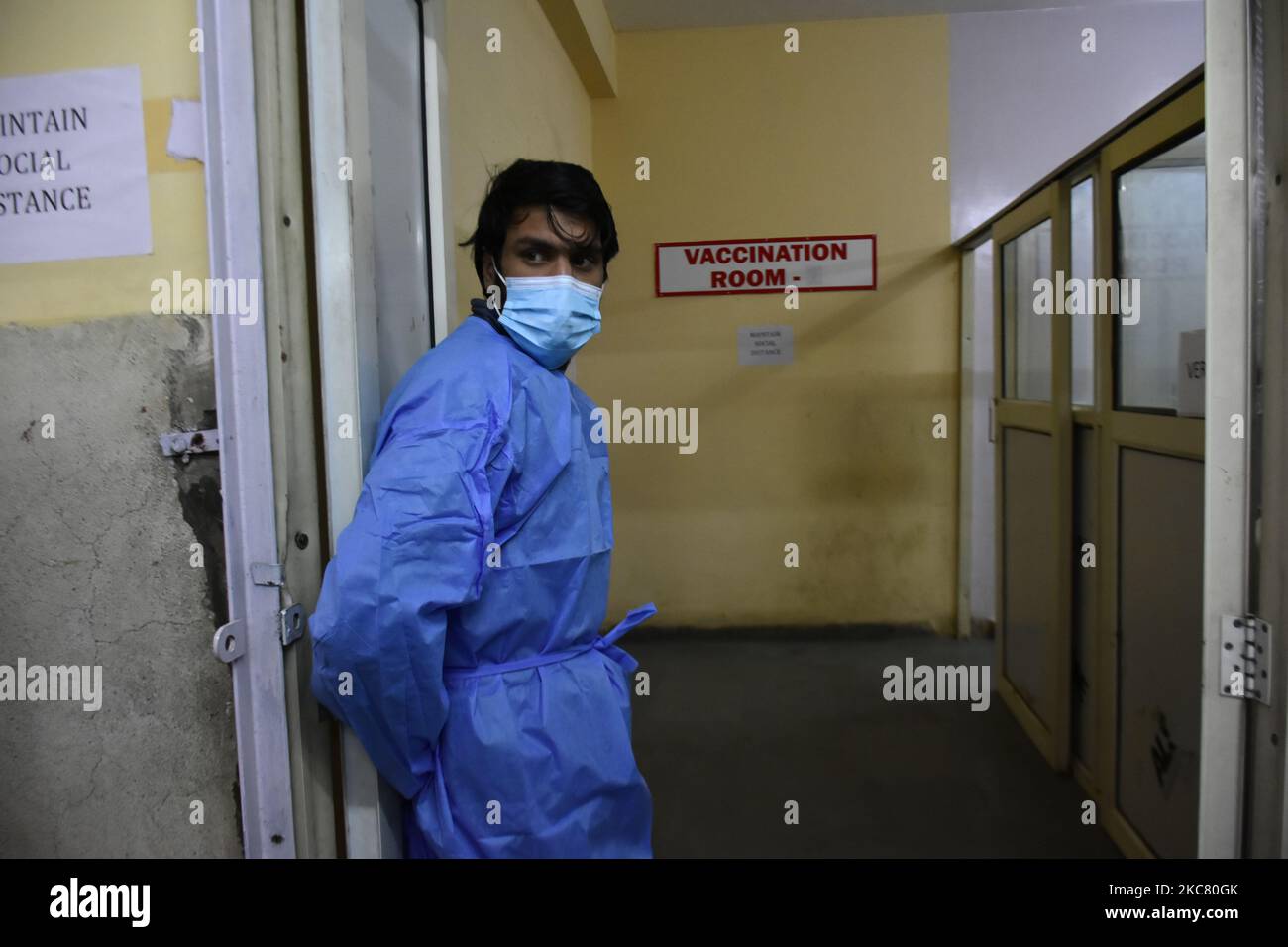A health worker stands outside the vaccination room at a hospital in ...