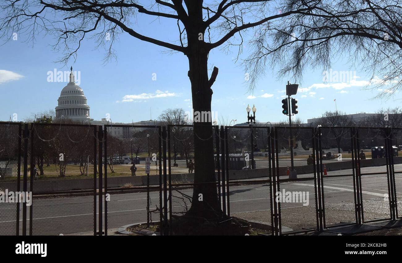 A protective fence topped with razor wire and concrete barriers ...