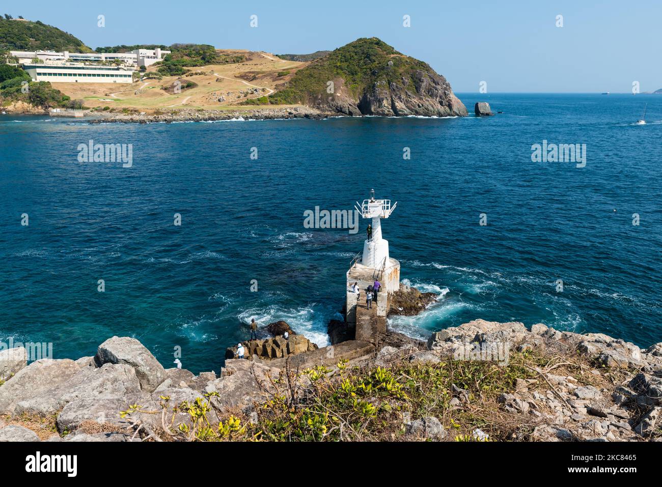 Hikers pose on the Tung Lung Chau lighthouse, while the Clearwater Bay ...