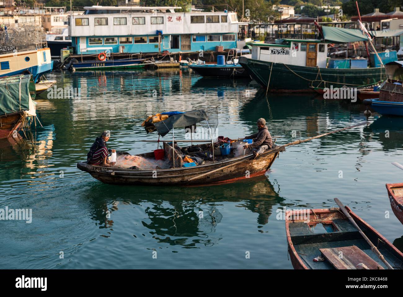 A couple of fishermen climb in their traditional junk boat in Lei Yue ...