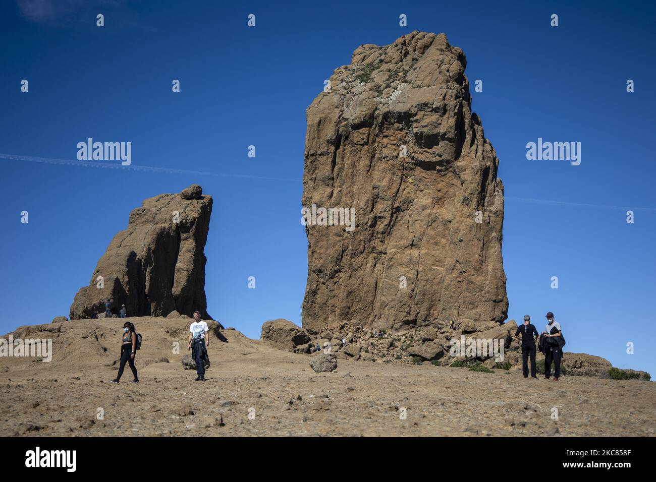 Visitors walk by rock formation called Roque Nublo is seen on the ...