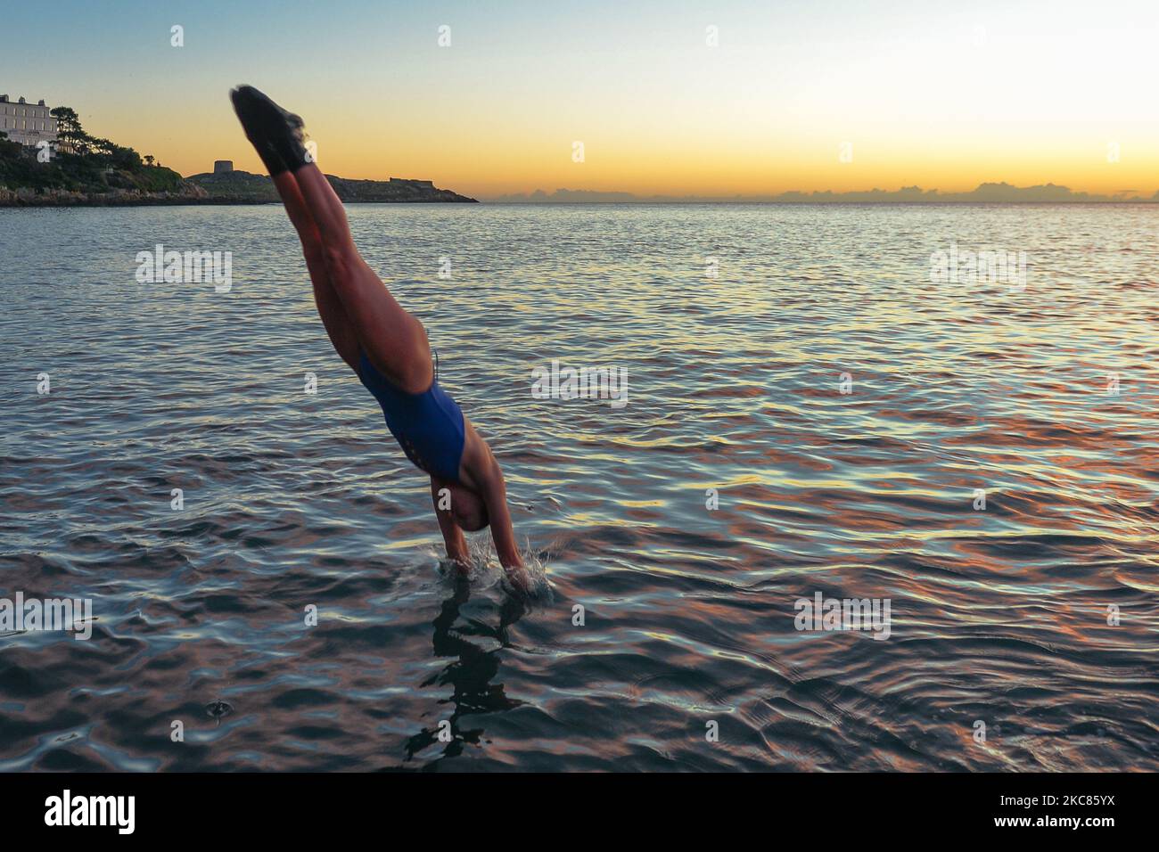 A swimmer jumps into the sea at the Vico bathing place, Hawk Cliff, in ...
