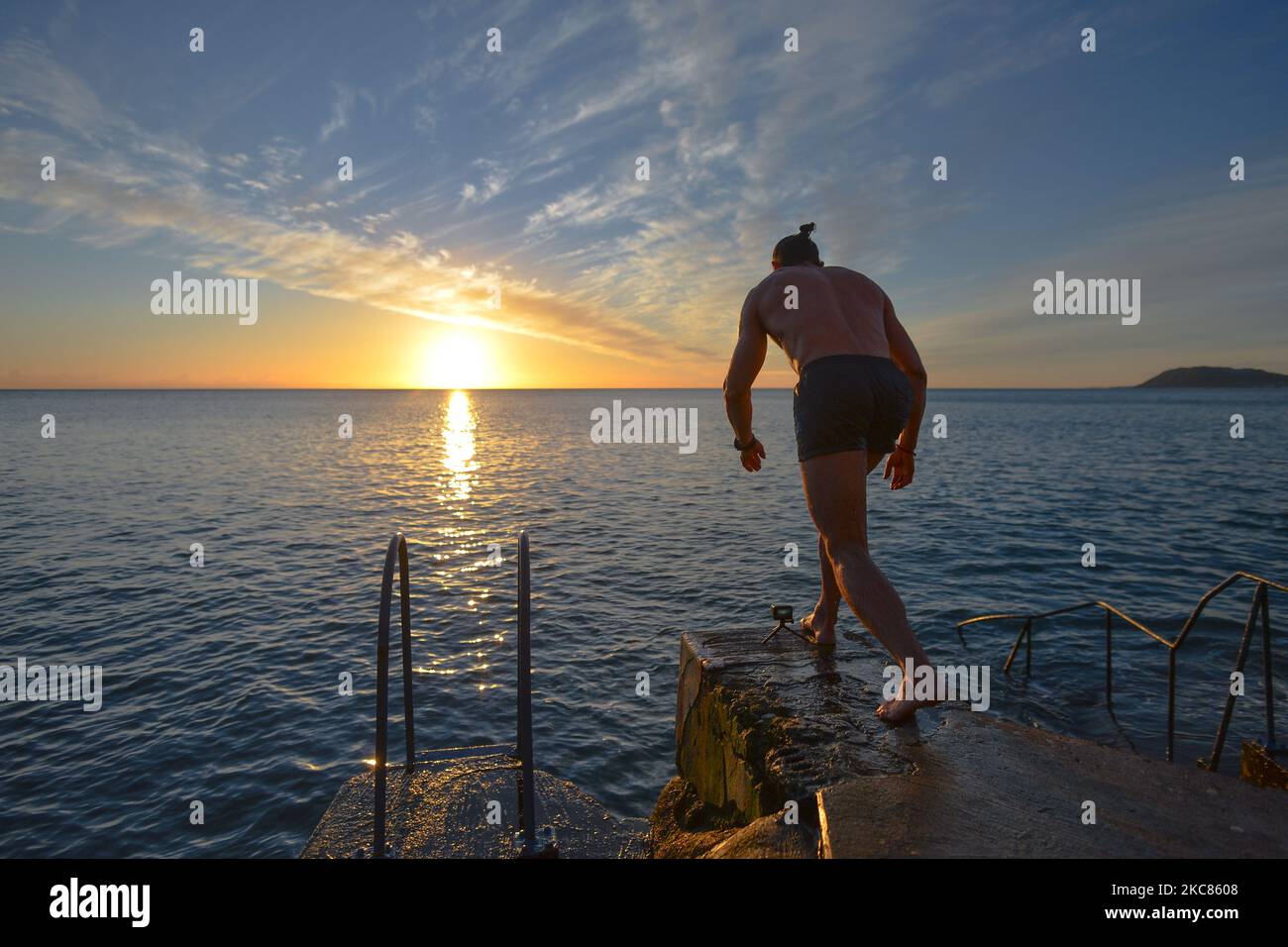 A swimmer jumps into the sea at the Vico bathing place, Hawk Cliff, in ...