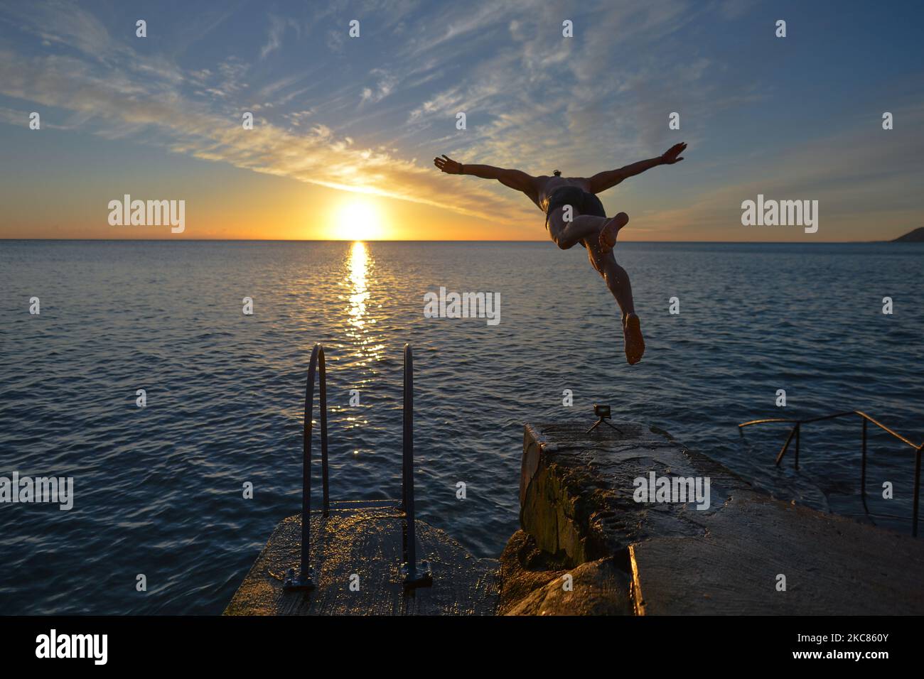 A swimmer jumps into the sea at the Vico bathing place, Hawk Cliff, in ...