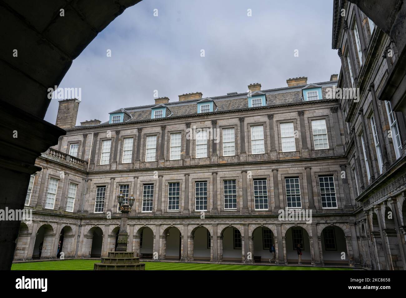 The Holyrood Palace courtyard surrounded by arches under cloudy sky in ...