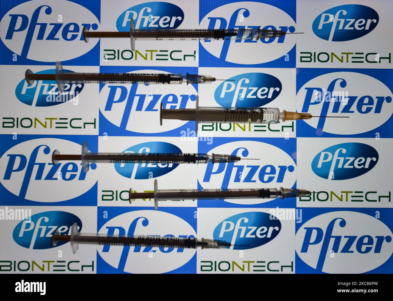 An illustrative image of medical syringes in front of a Pfizer logo ...