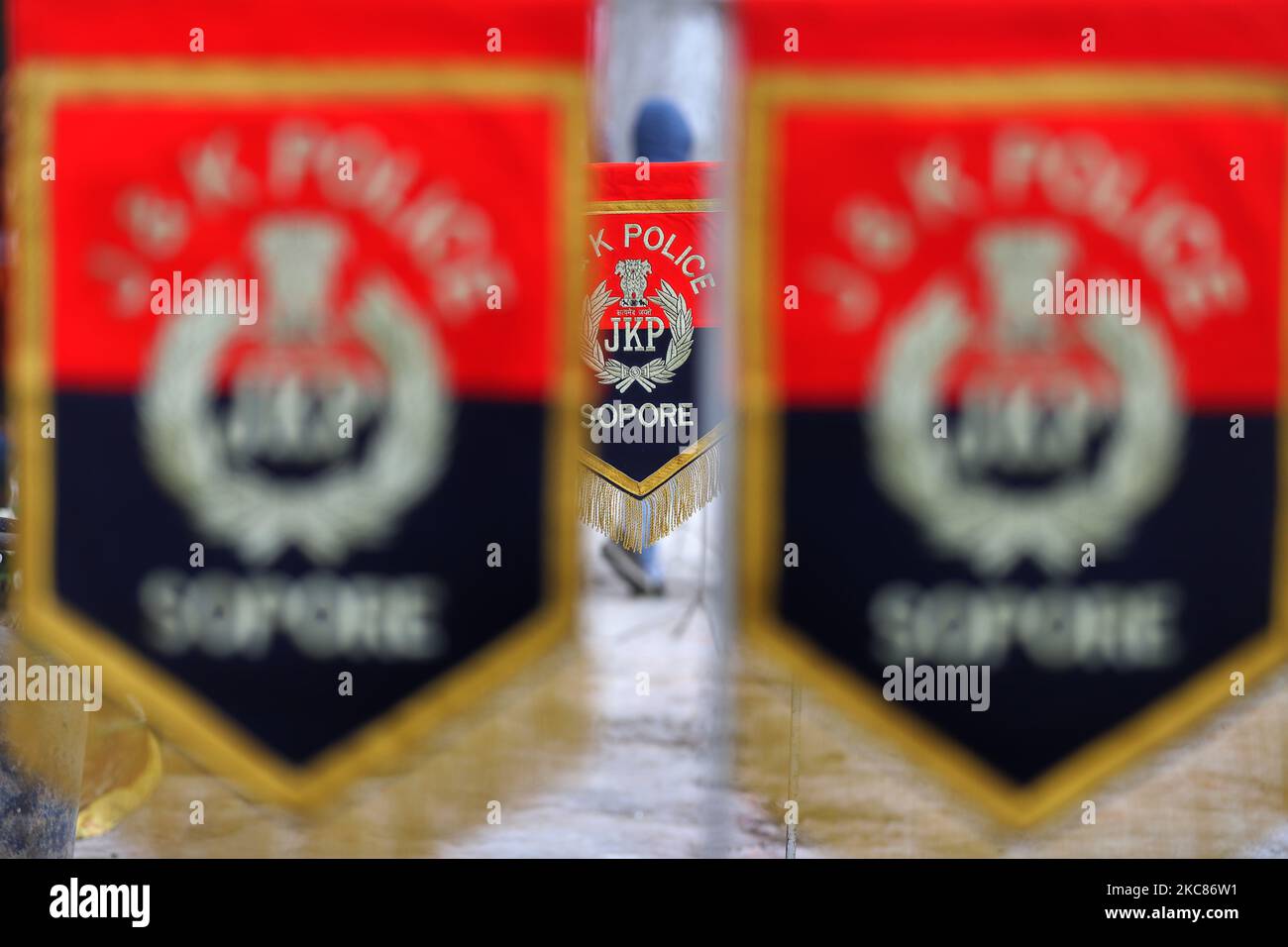 A man walks behind the JKP Police Sopore banner which were installed ...