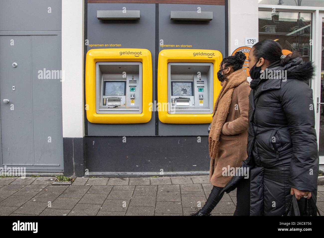 Two young women pass infront of the broken ATM machines. The aftermath ...