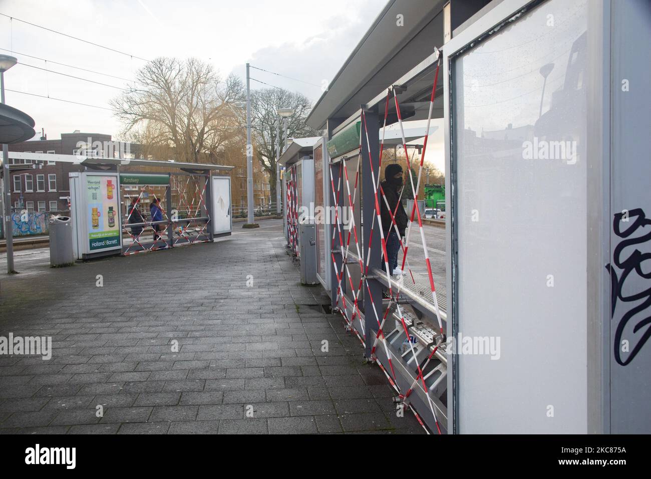 Damaged tram stop Randweg as seen with people wearing facemask. The ...