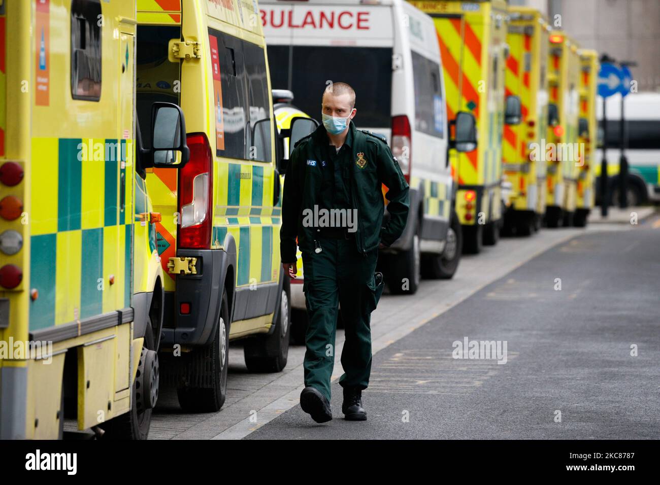A paramedic walks beside ambulances outside the emergency department of ...