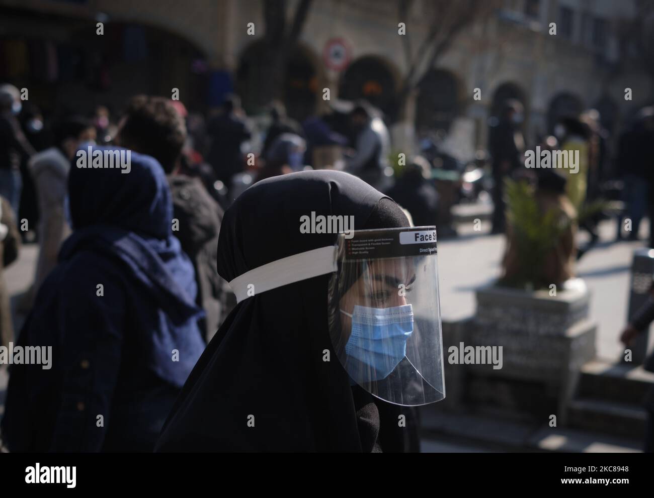 An Iranian veiled woman wearing a protective face mask and a face ...