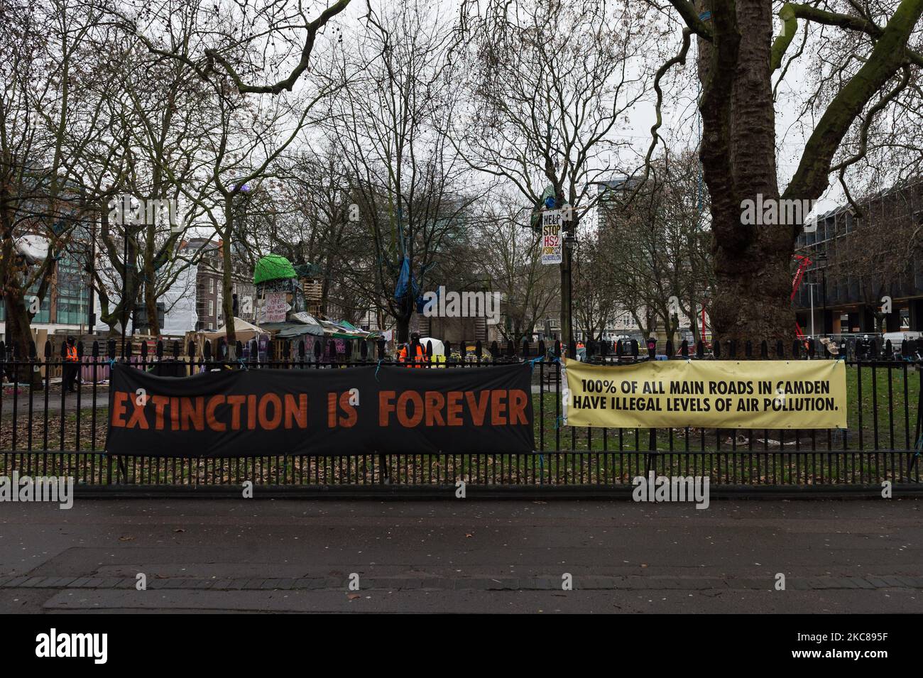 Protest banners hang on the fence as police carry out an operation to ...