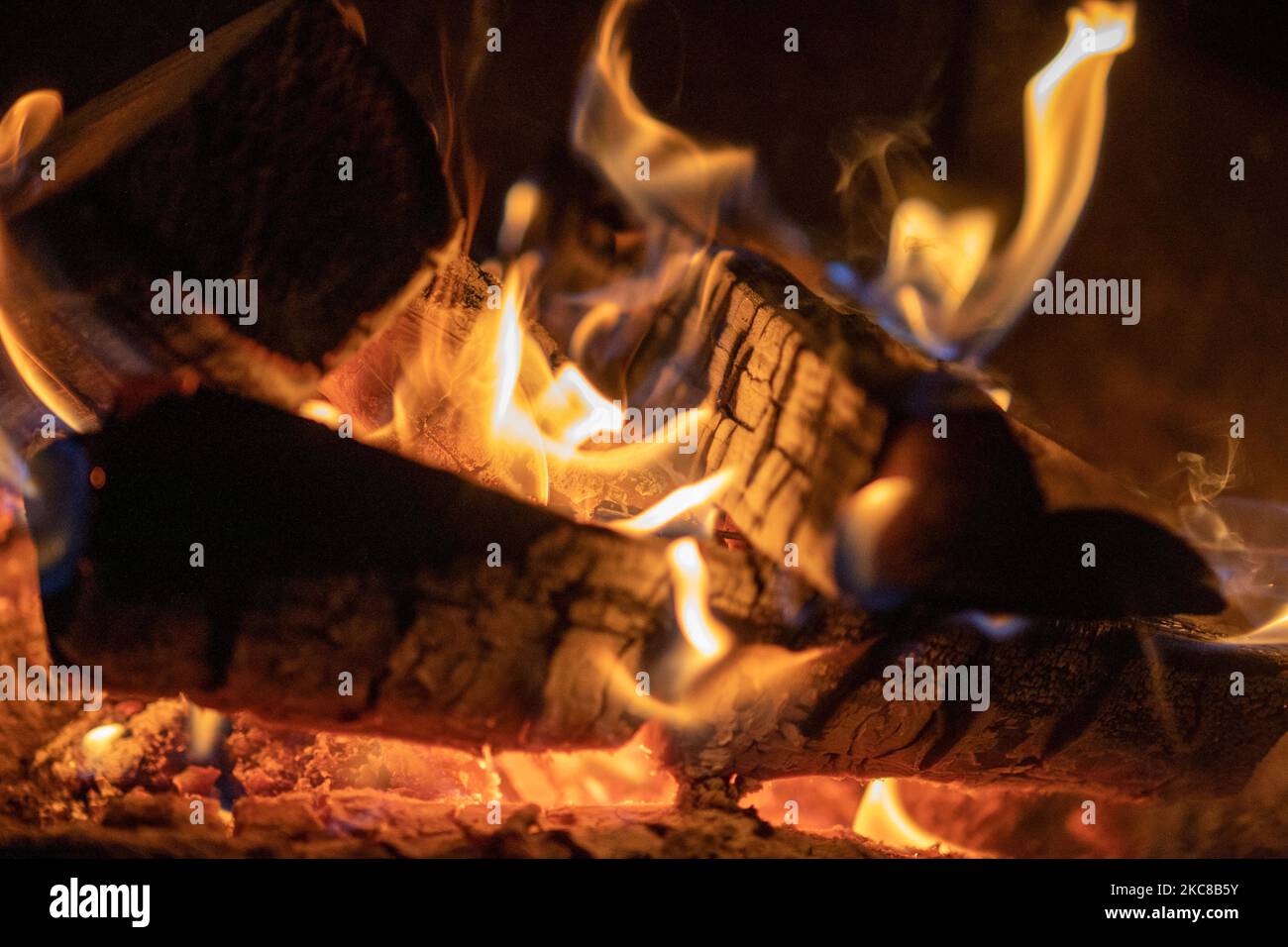 A closeup of the wooden logs burning in the dark Stock Photo - Alamy