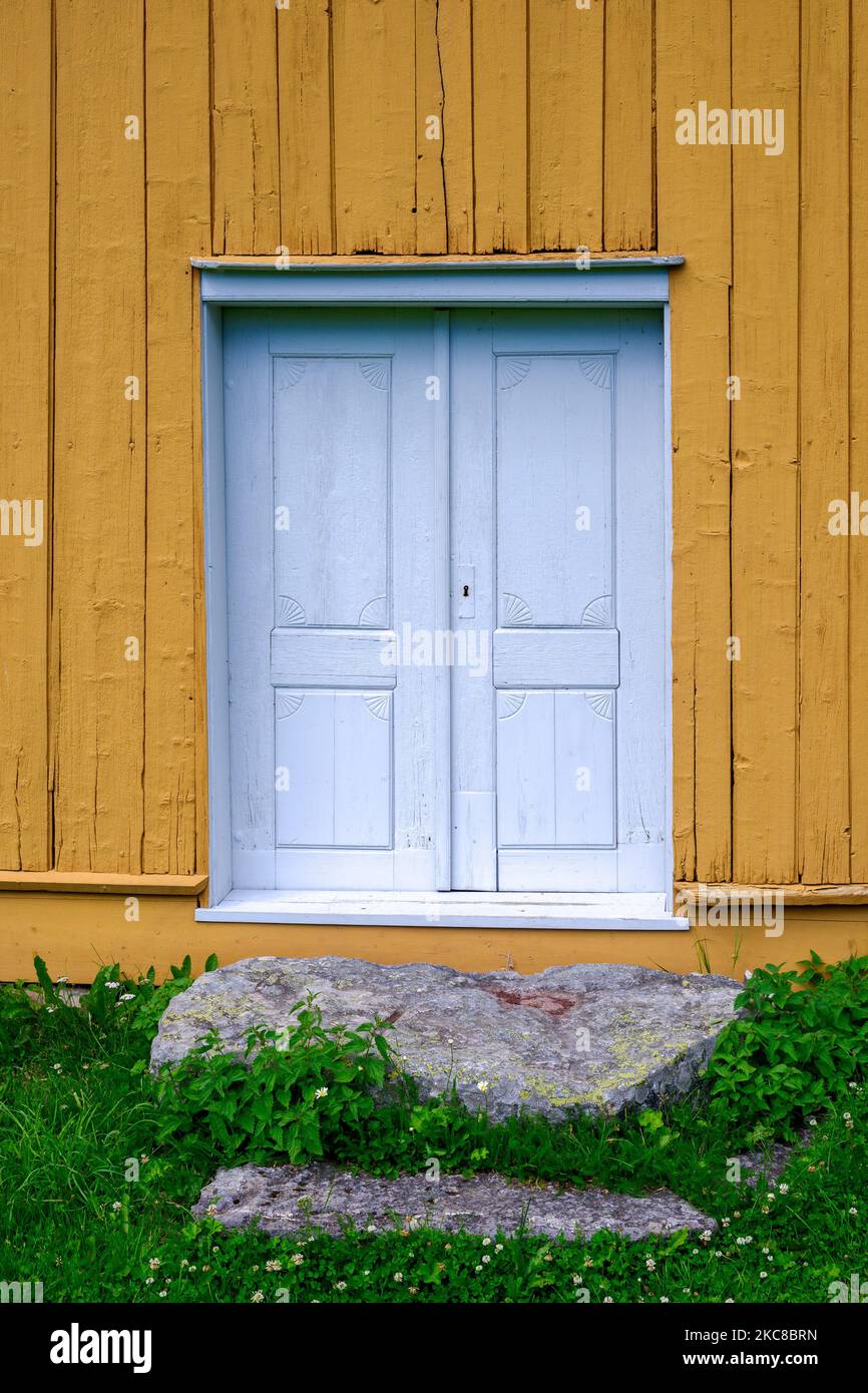 A vertical shot of a wooden door in ochre yellow wall Stock Photo - Alamy