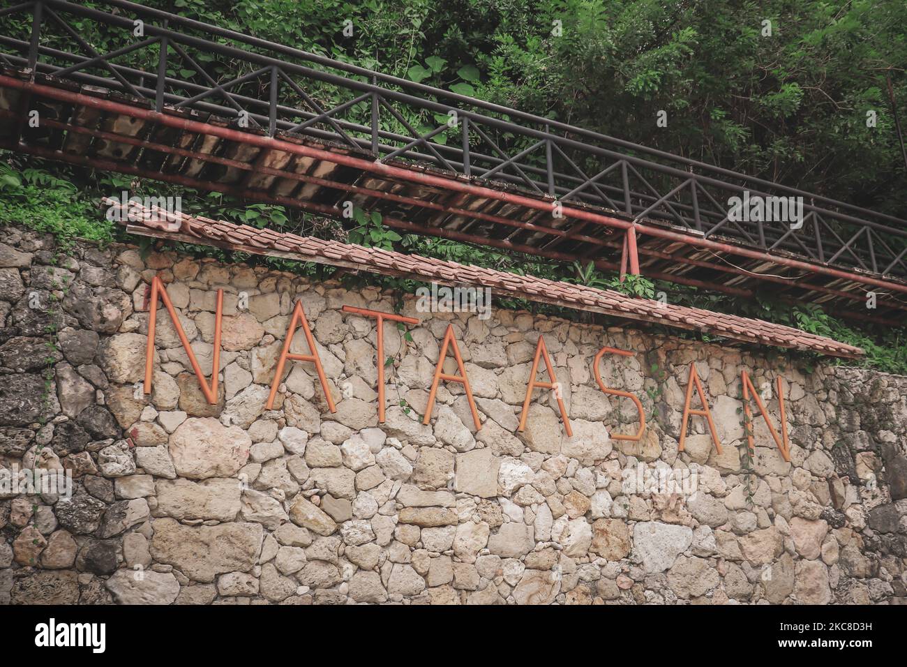 The sign of Nataasan Beach Resort under a footbridge in the Philippines ...