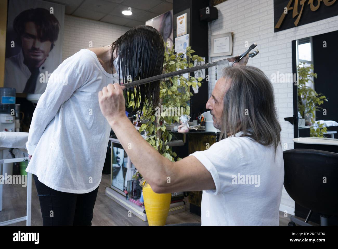 Hairdresser Alberto Olmedo demonstrates cutting a woman's hair using ...