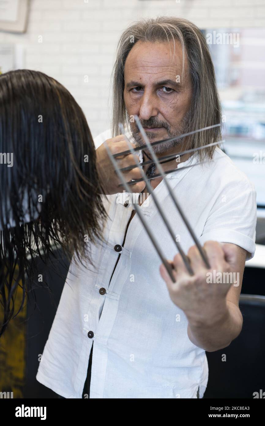Hairdresser Alberto Olmedo demonstrates cutting a woman's hair using ...