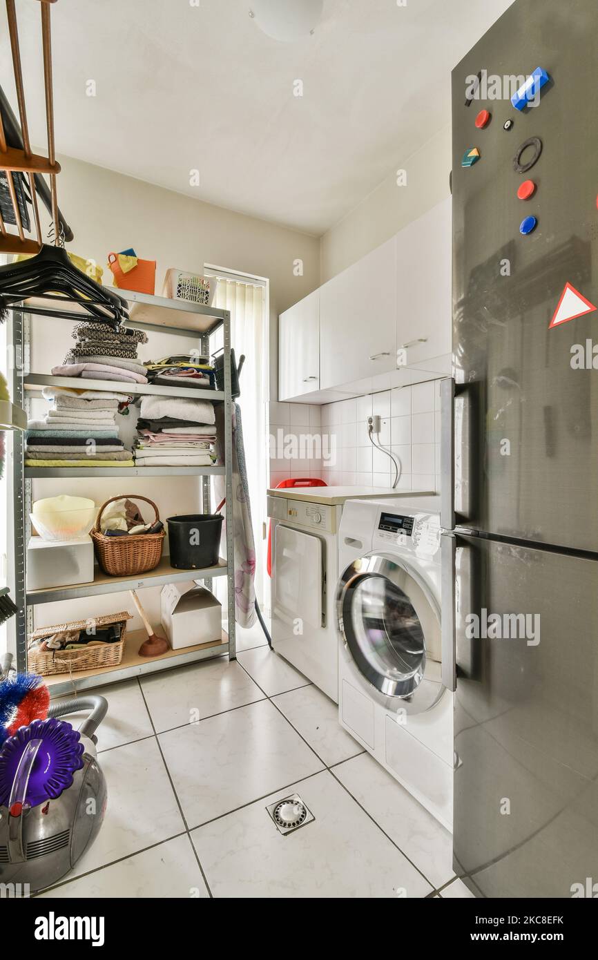 Modern cupboard in spacious room with white walls and washing machine ...
