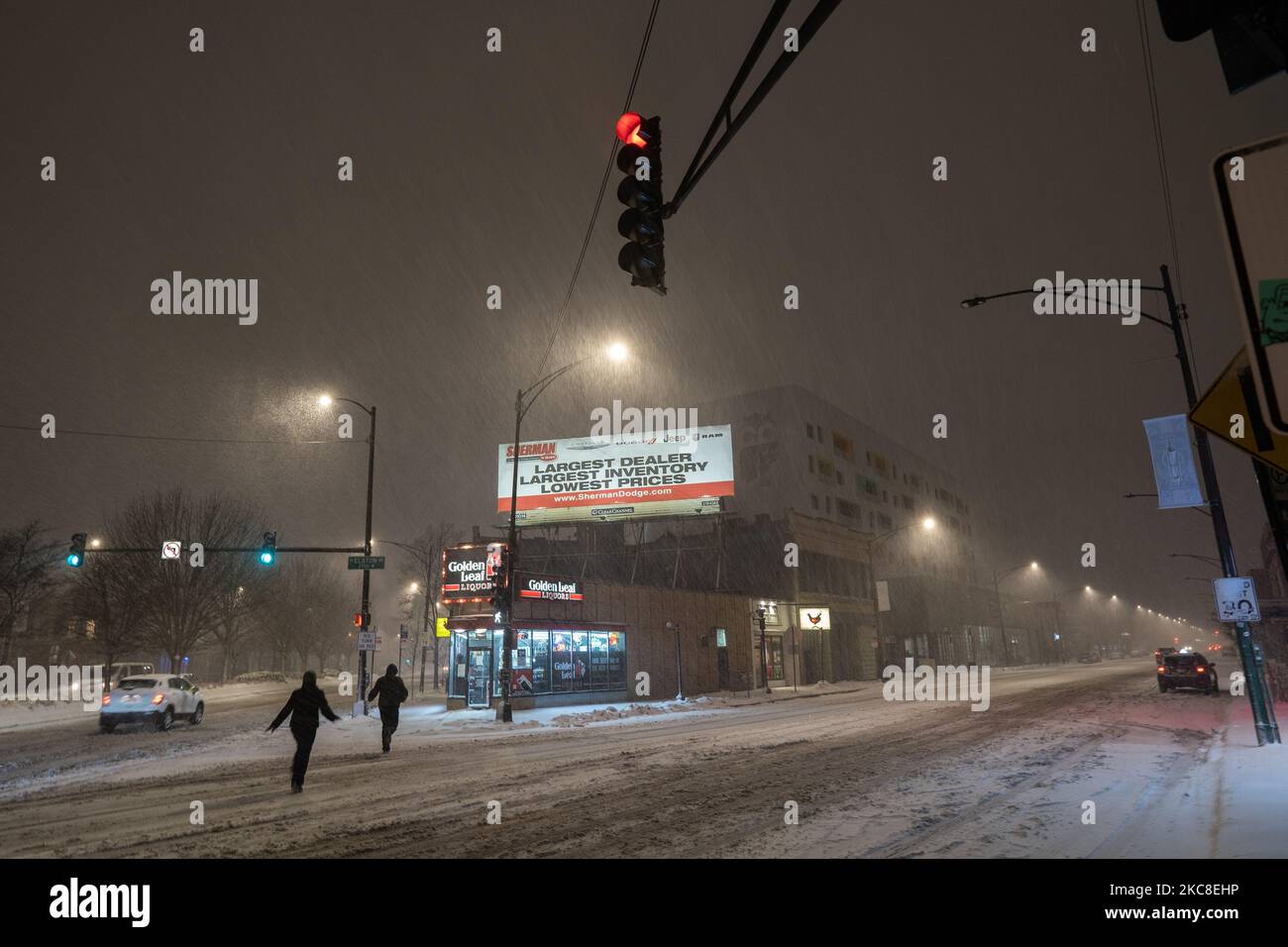 People run across the street in heavy winds and snow during a Winter ...