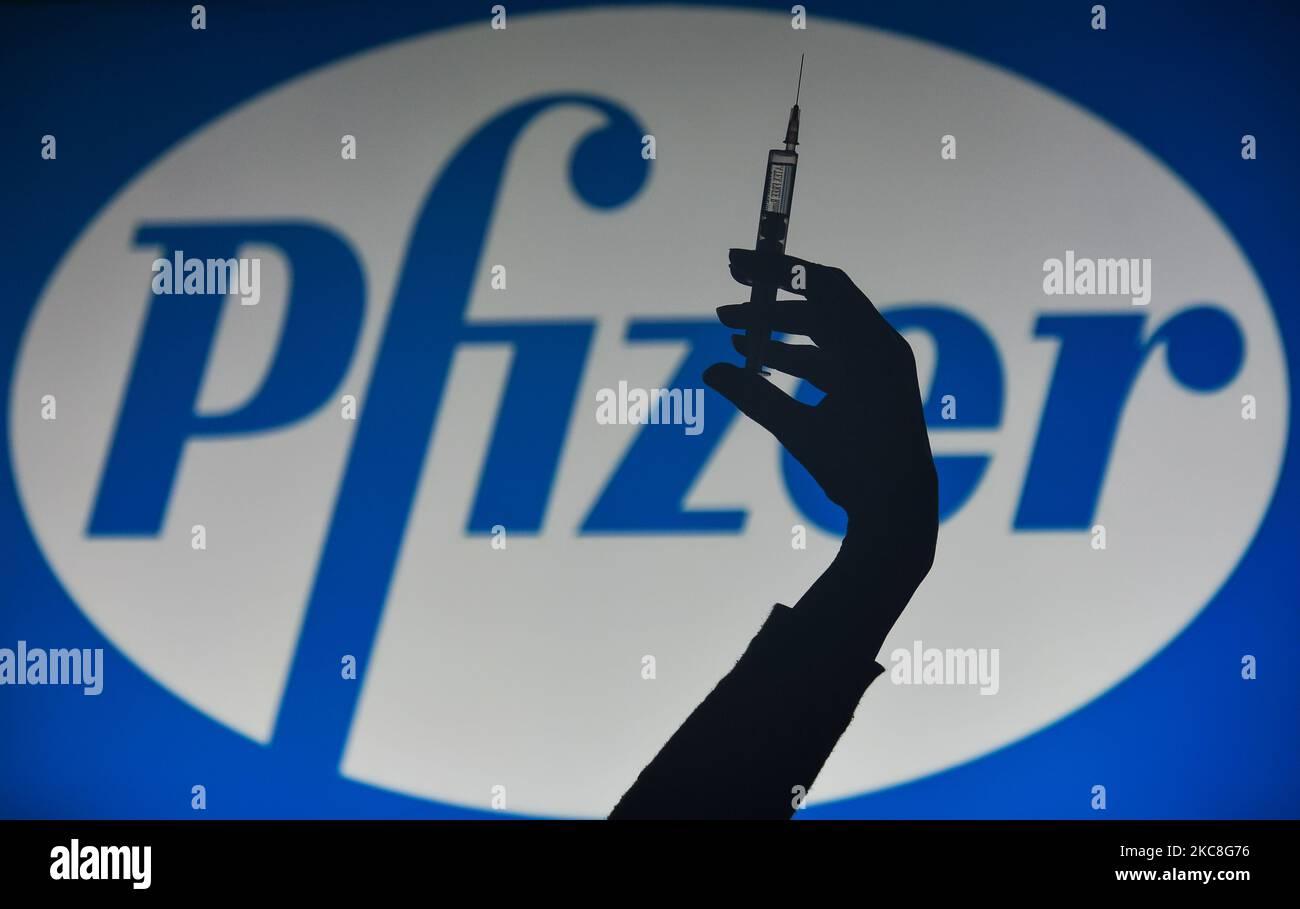 An illustrative image of a hand holding a medical syringe in front of ...