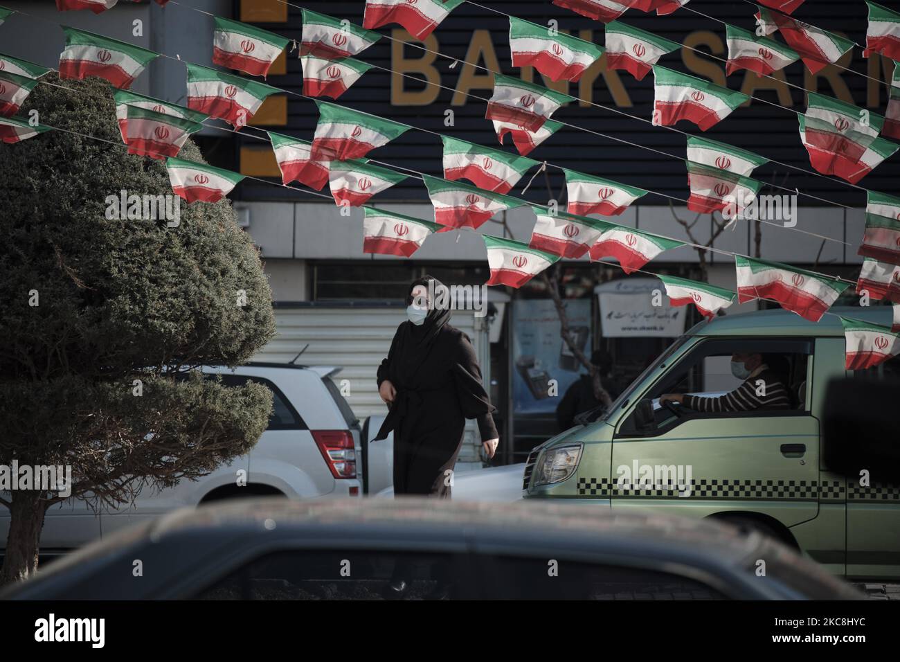 An Iranian woman wearing a protective face mask walks in Fatemi square ...