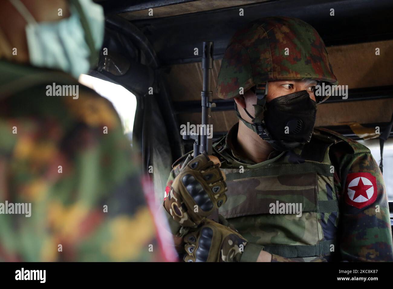 Myanmar soldiers sit in a military vehicle outside the Sri Sri Durga ...