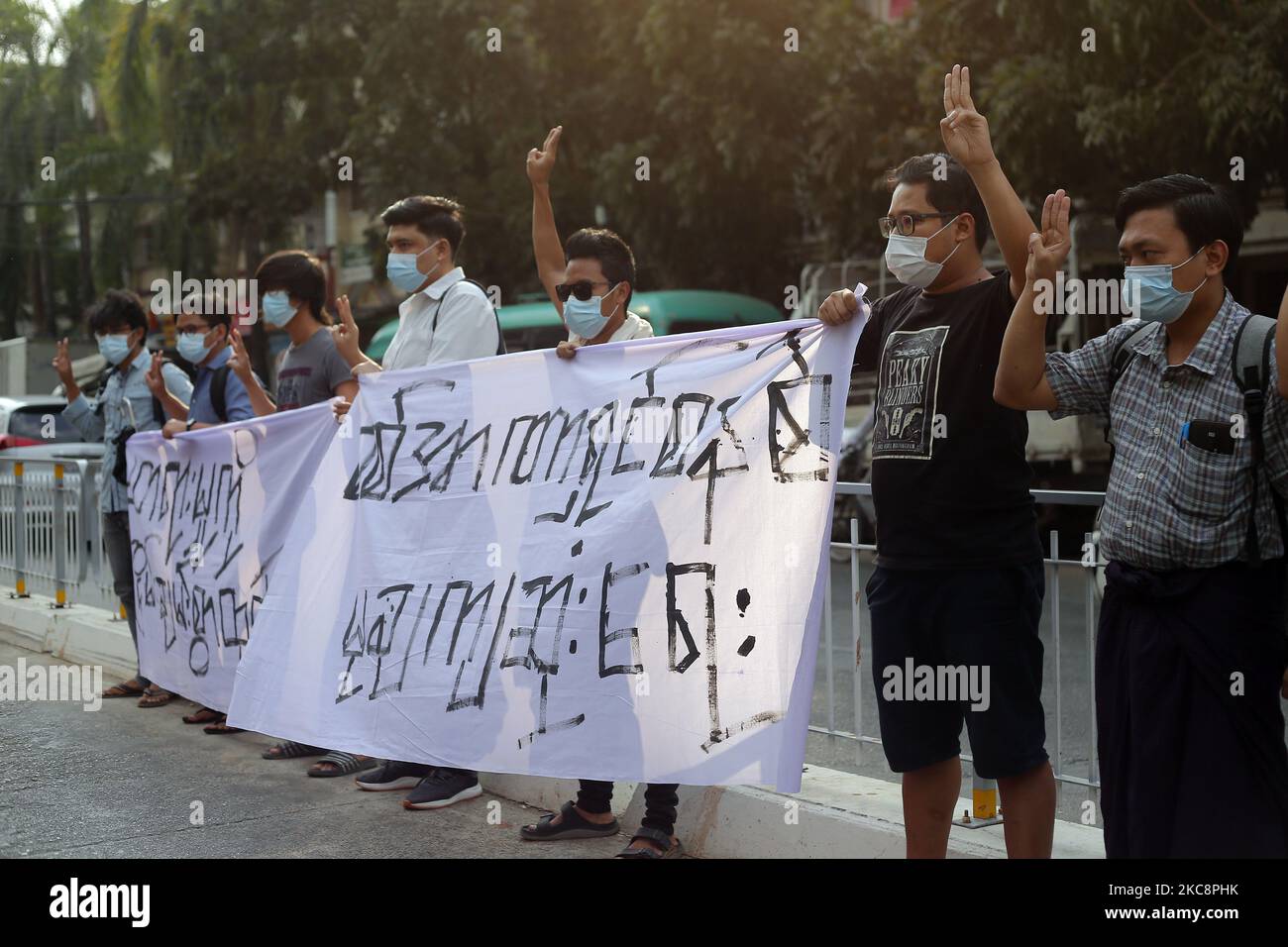 Myanmar youth protesters make the three finger salute on the street ...