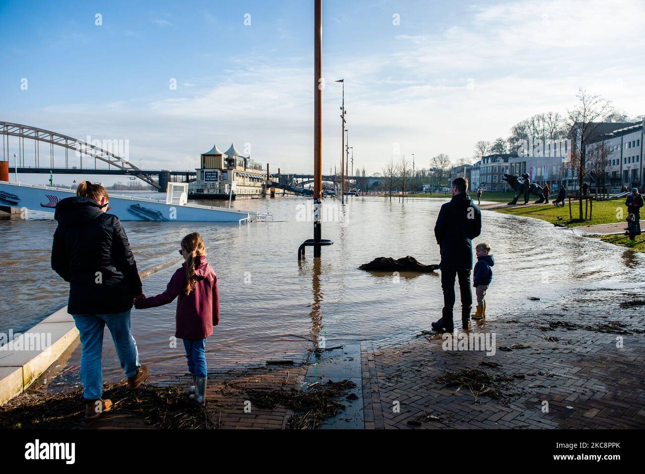 A family is watching the Waal river flooding, during the high water ...