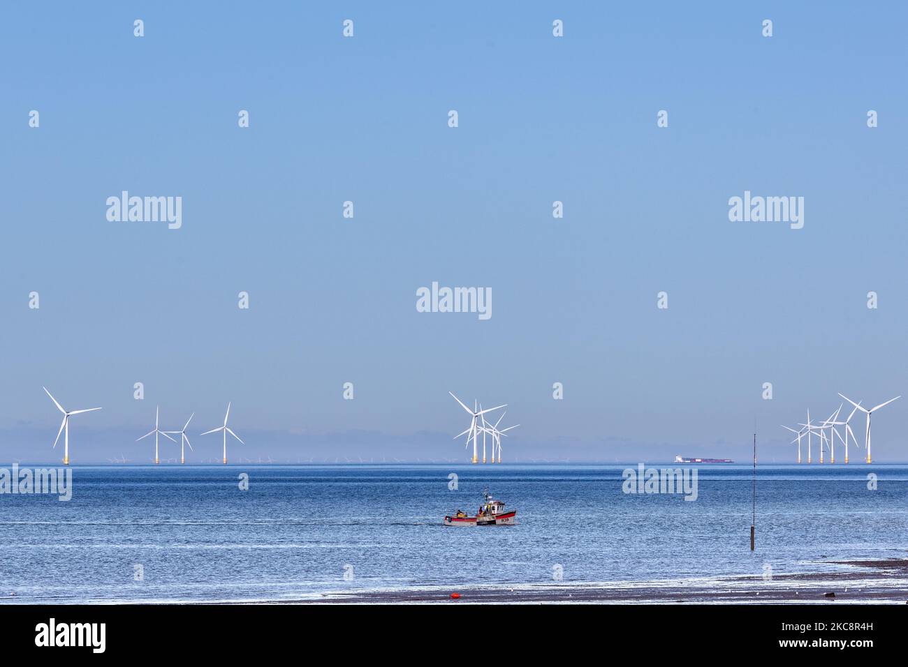 Fishing vessel in front of windmills on the sea on a sunny winter day ...
