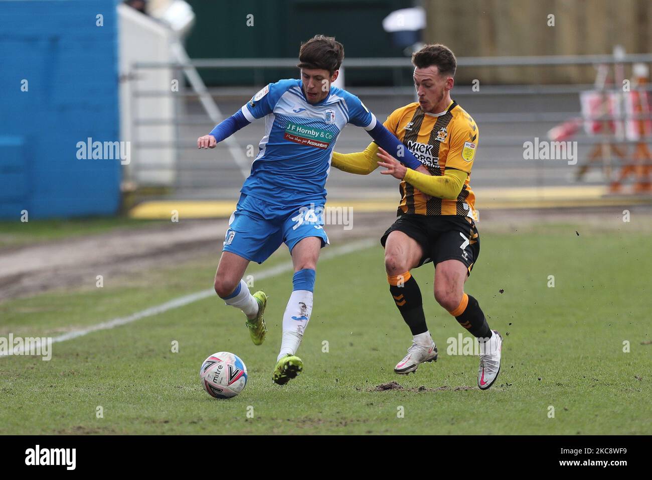 Jamie Devitt of Barrow in action with Luke Hannant of Cambridge United ...