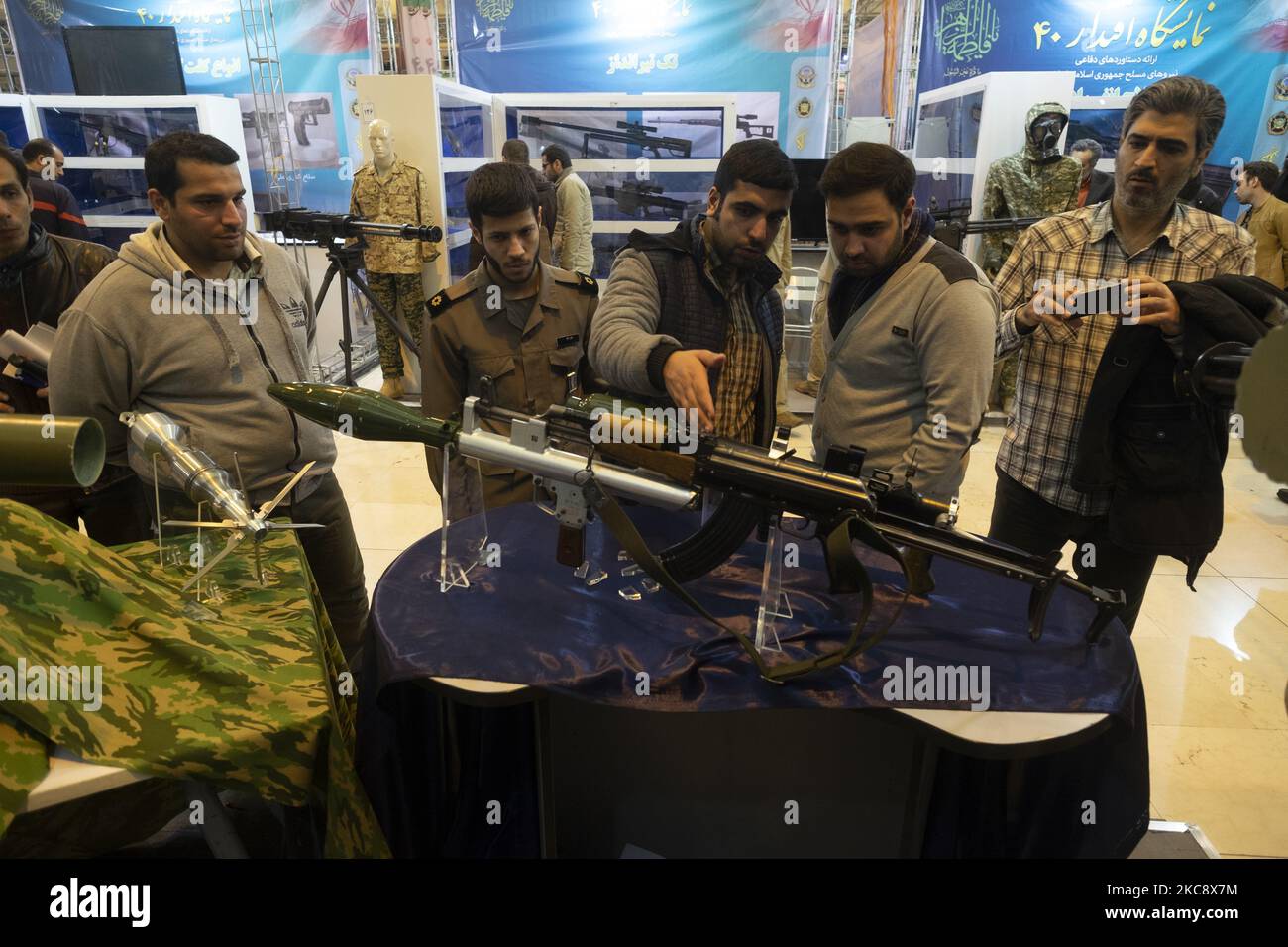 File Photo shows, Two visitors talk to each other about a gun displayed ...
