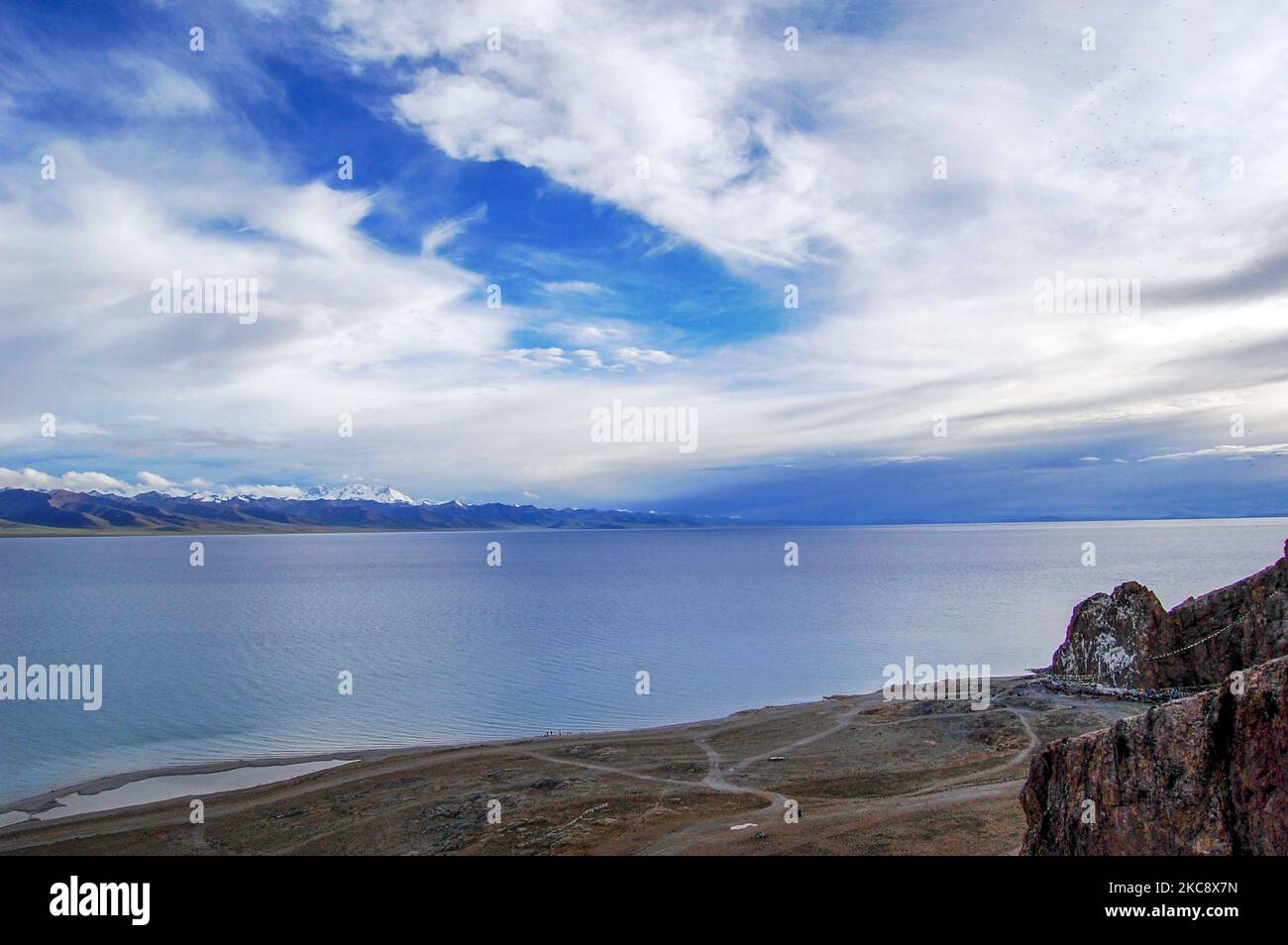 A beautiful view of a lake with hills and a blue sky in the background ...