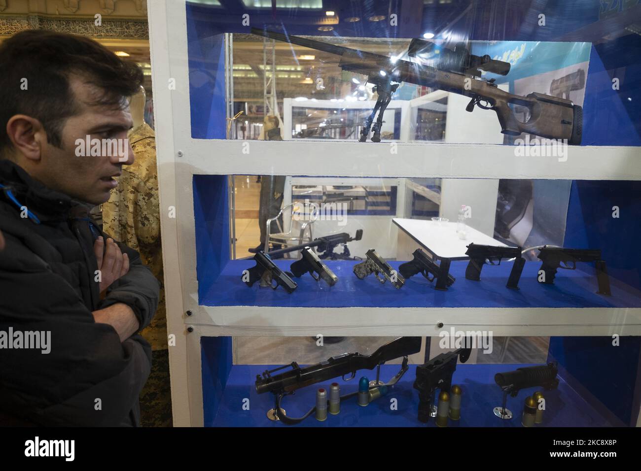 File Photo shows, An Iranian visitor looks on a gun and pistols ...