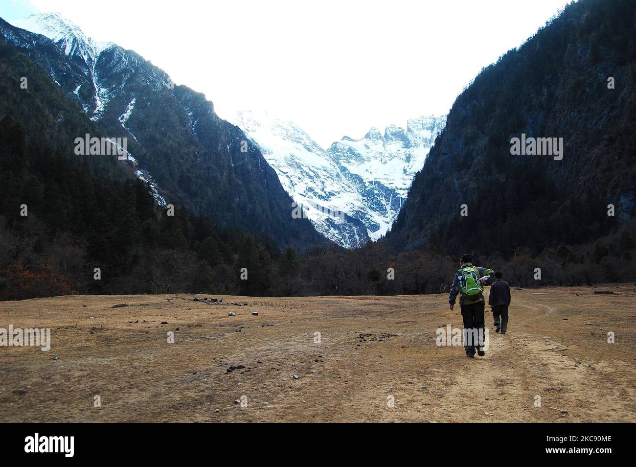 A beautiful view of men walking among the hills with a snowy mountain ...