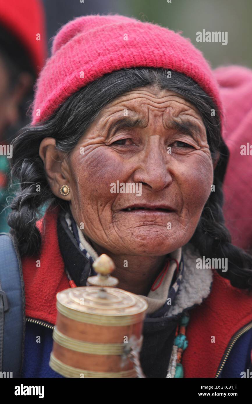 Ladakhi woman spins a hand-held prayer wheel as she watches Buddhist ...