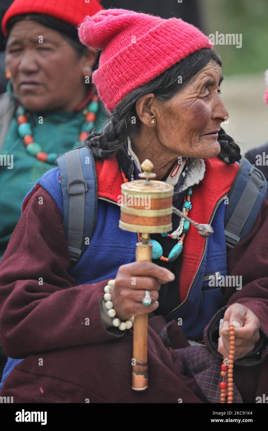 Ladakhi women spin prayer wheels and hold prayer beads as they watch ...