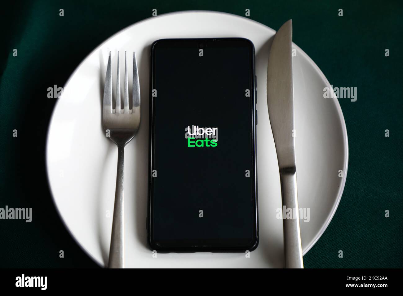 Uber Eats app logo is displayed on a mobile phone screen photographed ...