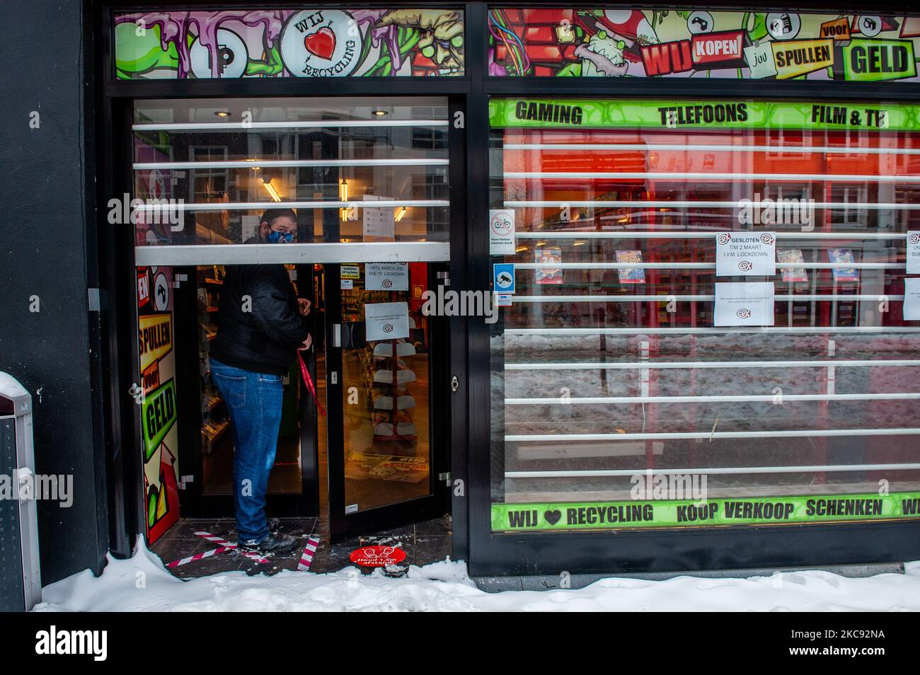 A man is getting ready his game shop to re open just for order pickups ...