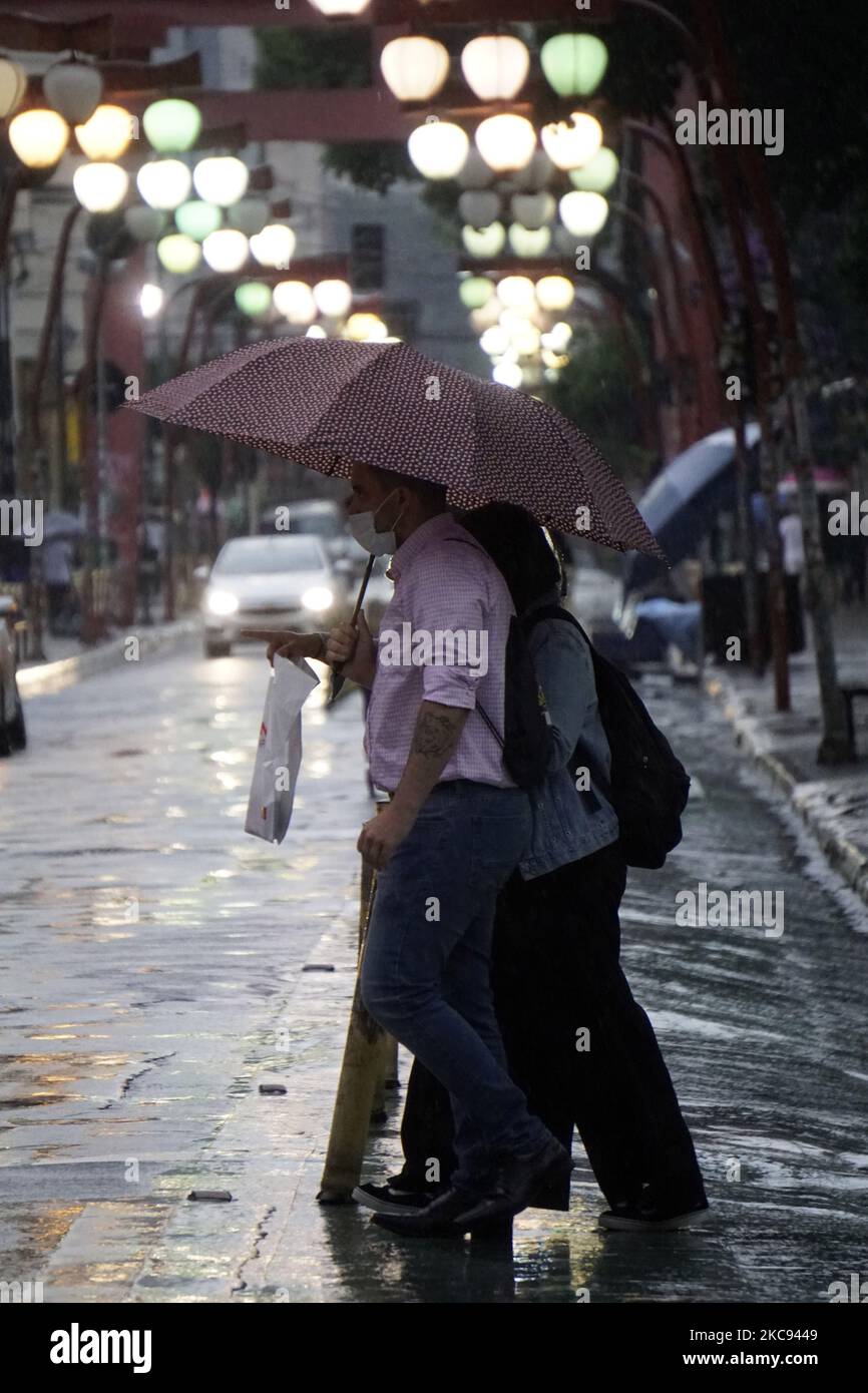 Pedestrians walk on a rainy day through the streets of São Paulo ...