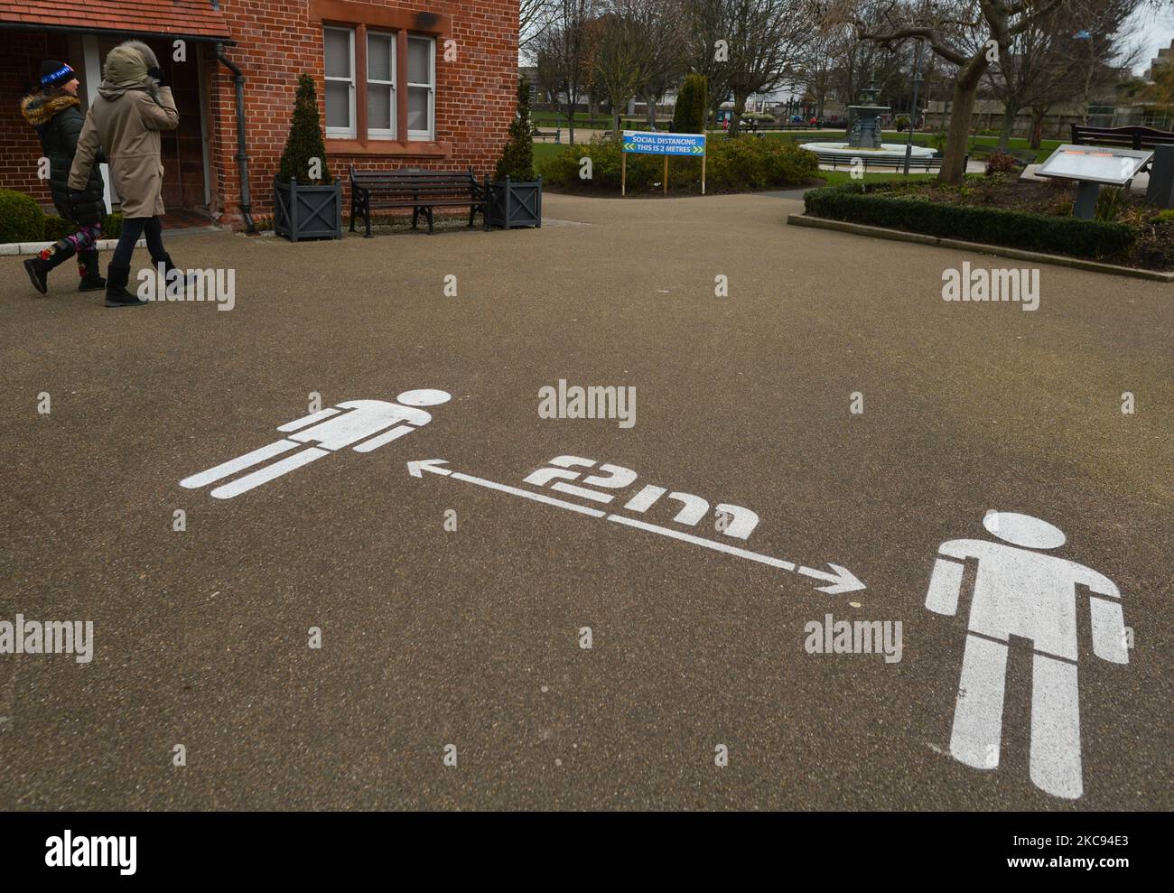 People walking next to a social distancing 2m sign in People's Park ...