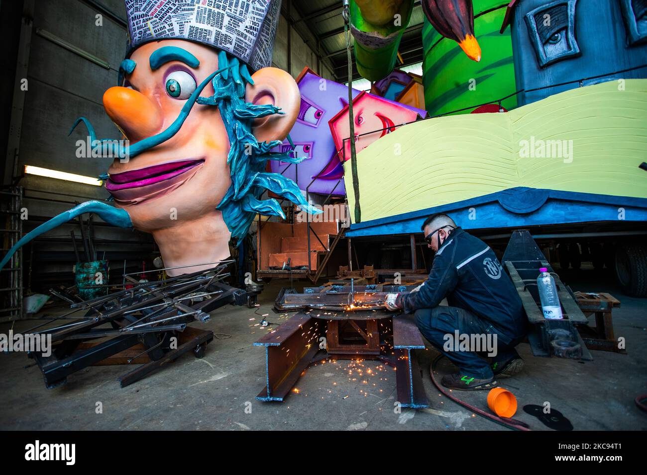 People at work inside a warehouse where the allegorical floats are ...